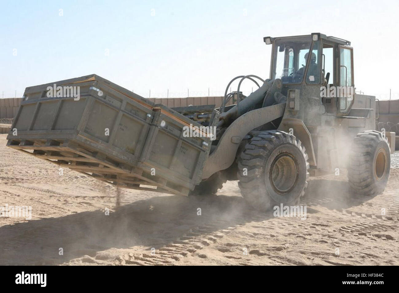 A military front-end loader, operated by a motor transport Marine with ...