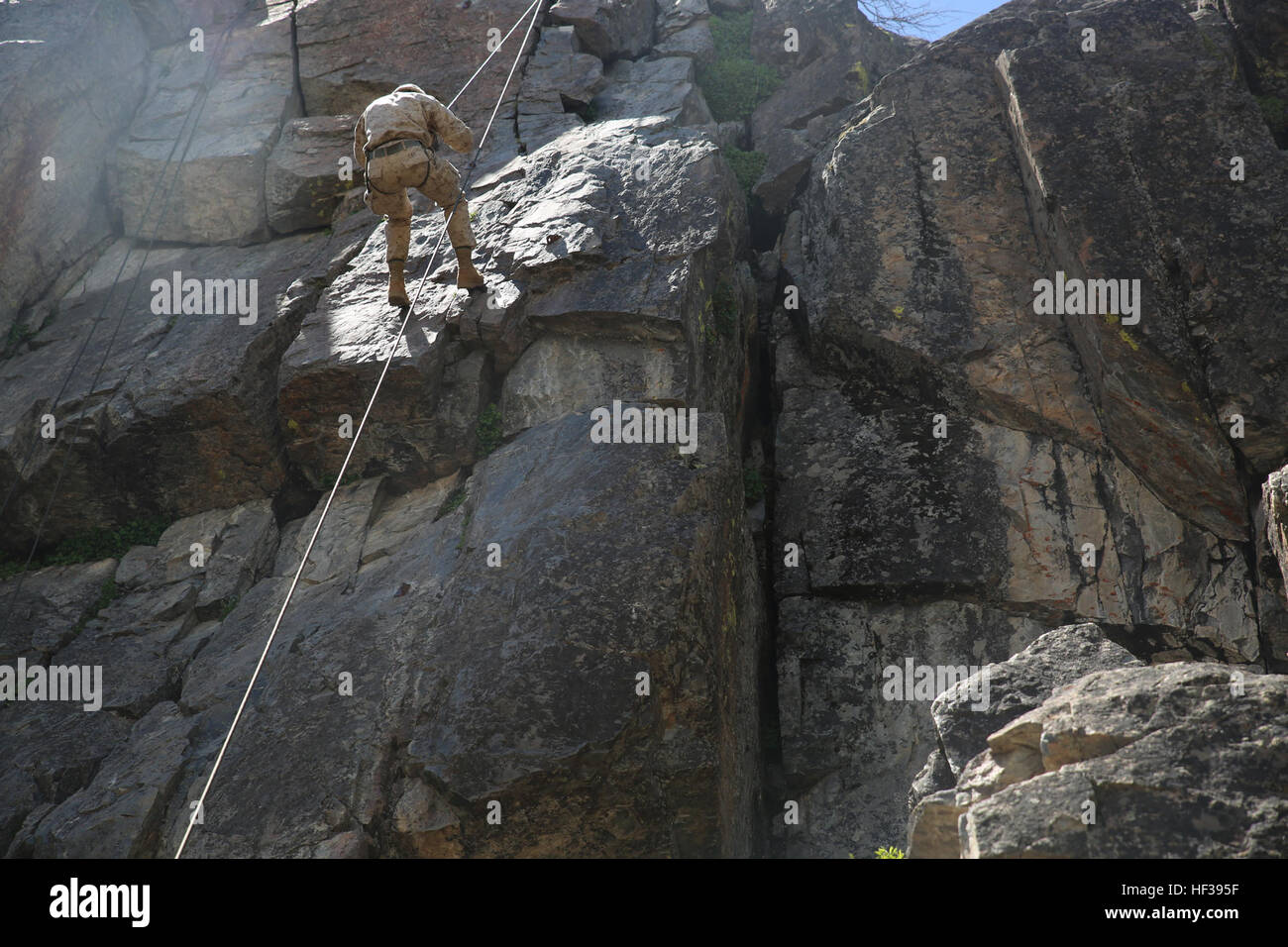 A Marine Corps anti-tank missile operator climbs a 40-foot cliff during ...