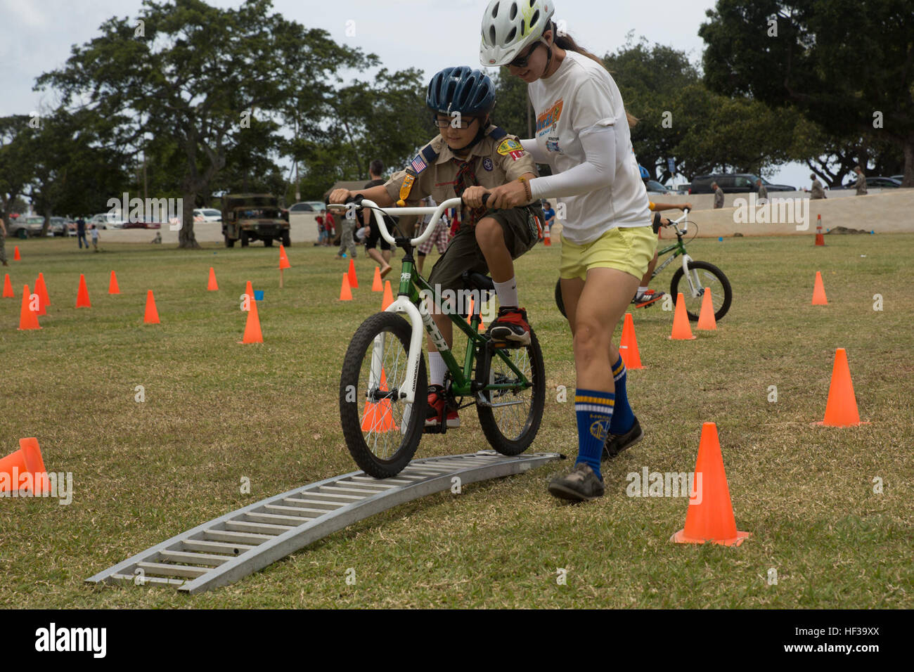 Kanani Alvarado, a bike instructor, helps guide a boy over a rail in a ...
