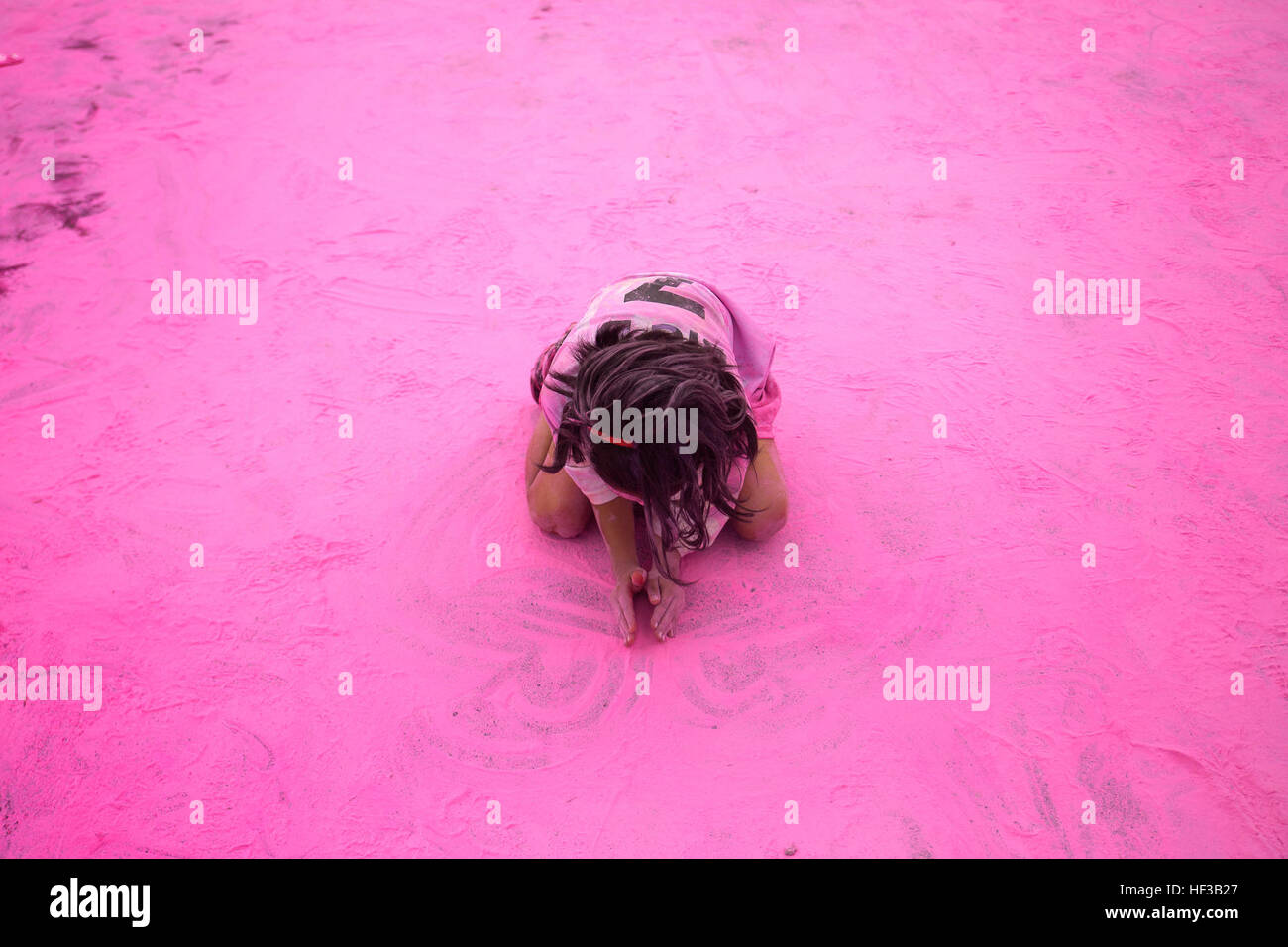 CAMP FOSTER, OKINAWA, Japan— A young girl scoops up pink powder to ...