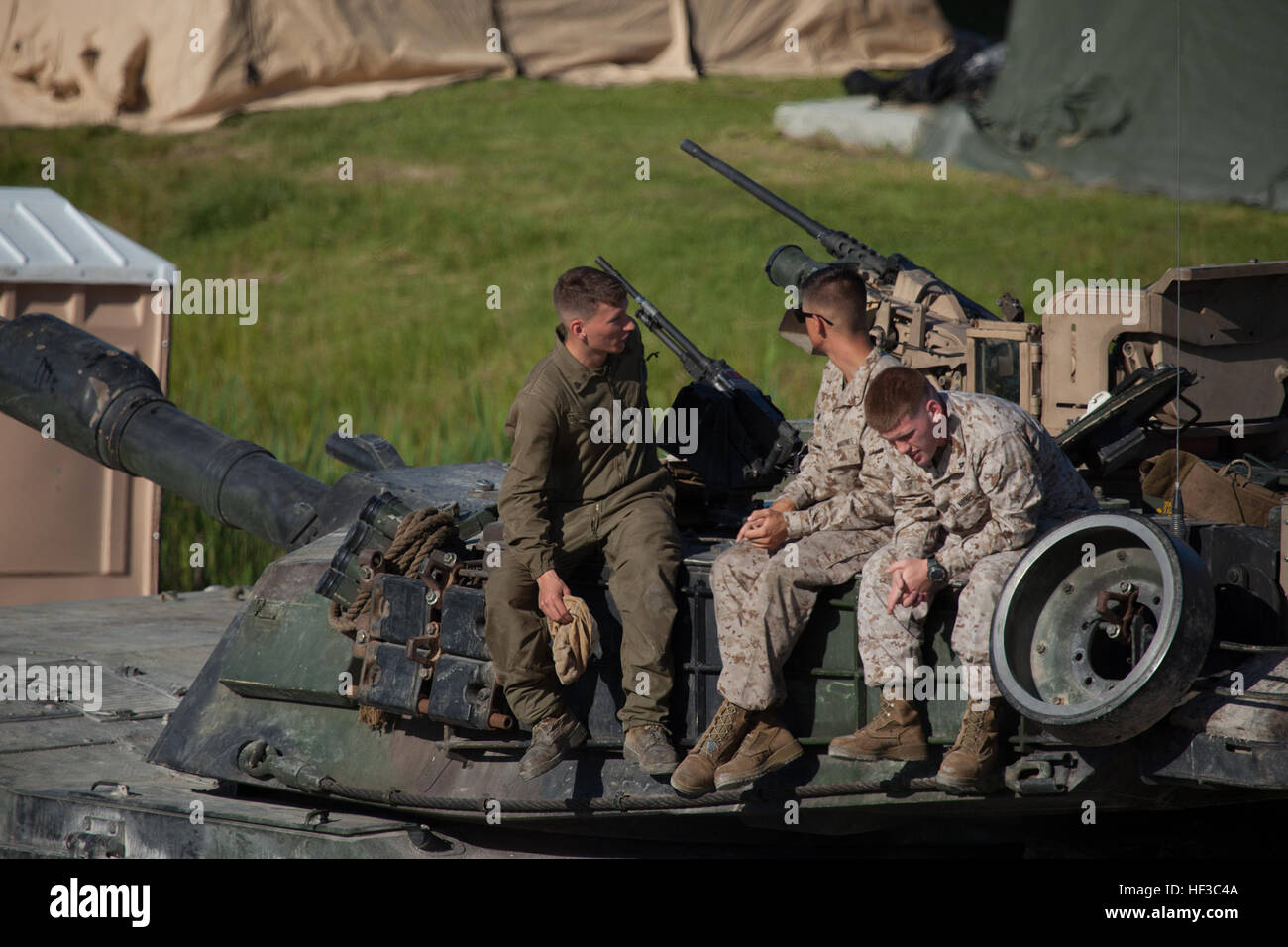 U.S. Marine Corps tank crewmen sit on a M1A1 Abram Tank while waiting ...