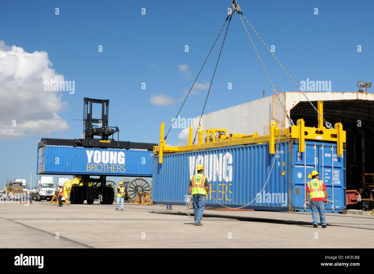 Dockworkers oversee the offloading of shipping containers from the ...