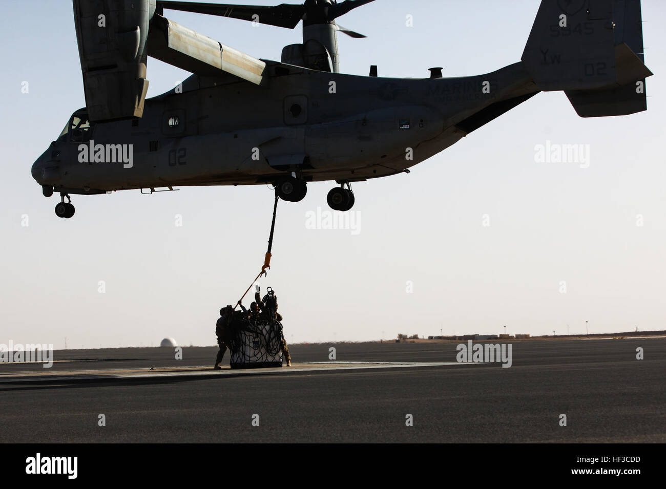 U.S. Marines and U.S. Army soldiers attach a 1,000-pound cargo load to ...
