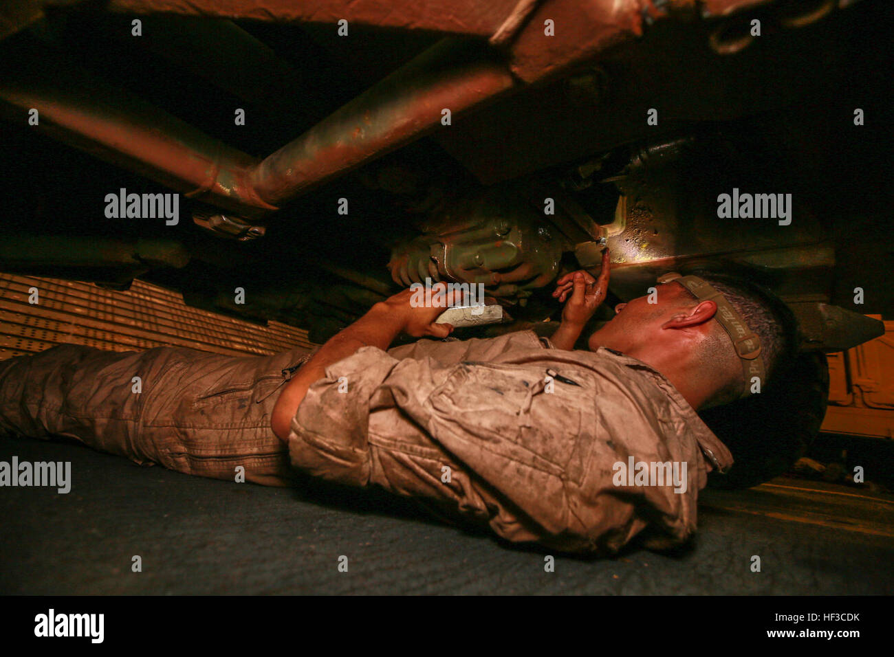U.S. Marine Cpl. Bryan Delgado performs vehicle maintenance on a Light ...