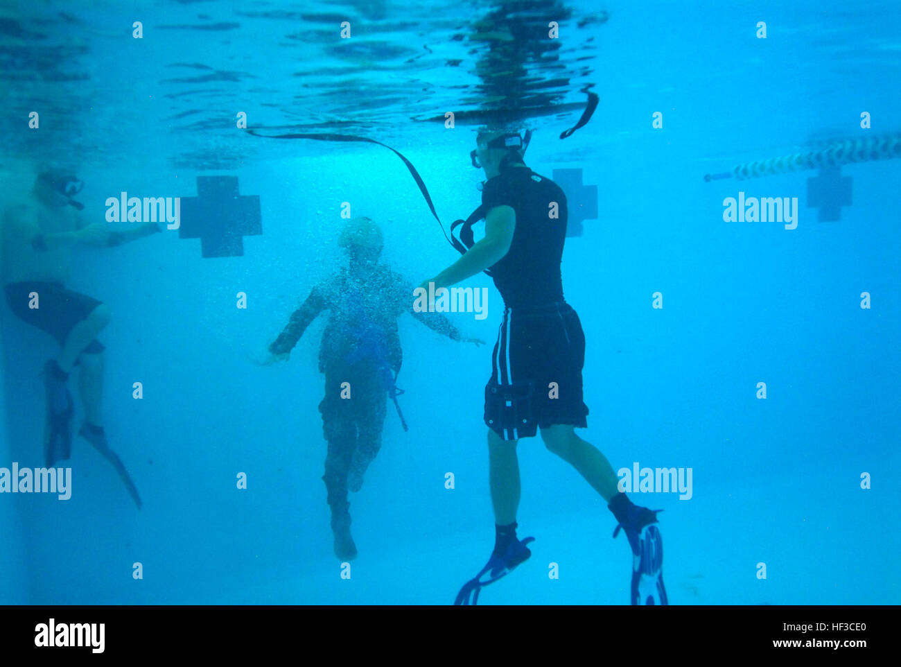A participant in the water survival training class jumps in the water ...