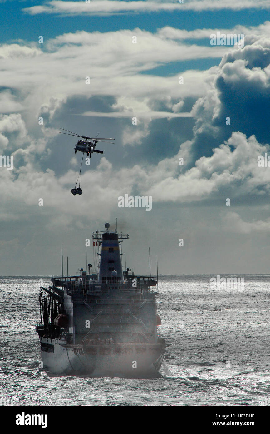 A U.S. Navy MH-60S Seahawk helicopter transfers supplies from fleet ...