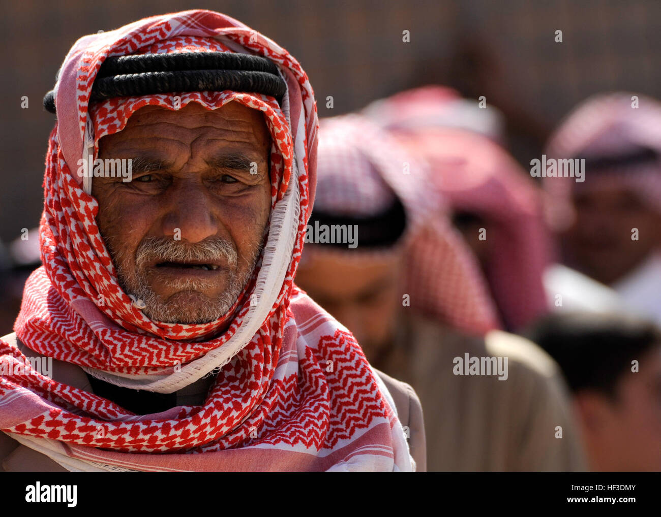 Iraqi men wait in line up outside the government headquarters building ...