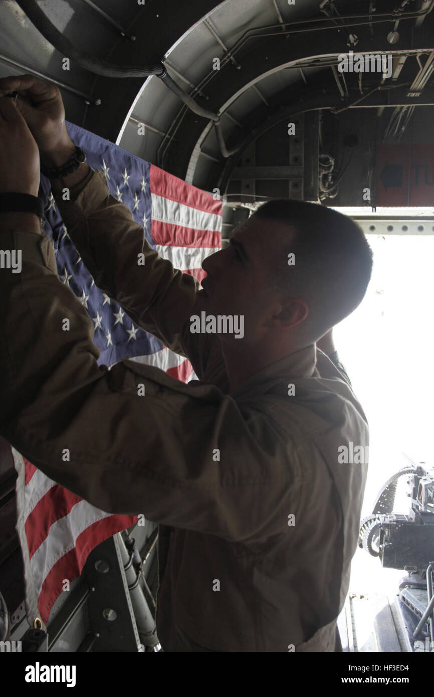 Cpl. James Rumpf hangs an American flag in his CH-53D Sea Stallion ...