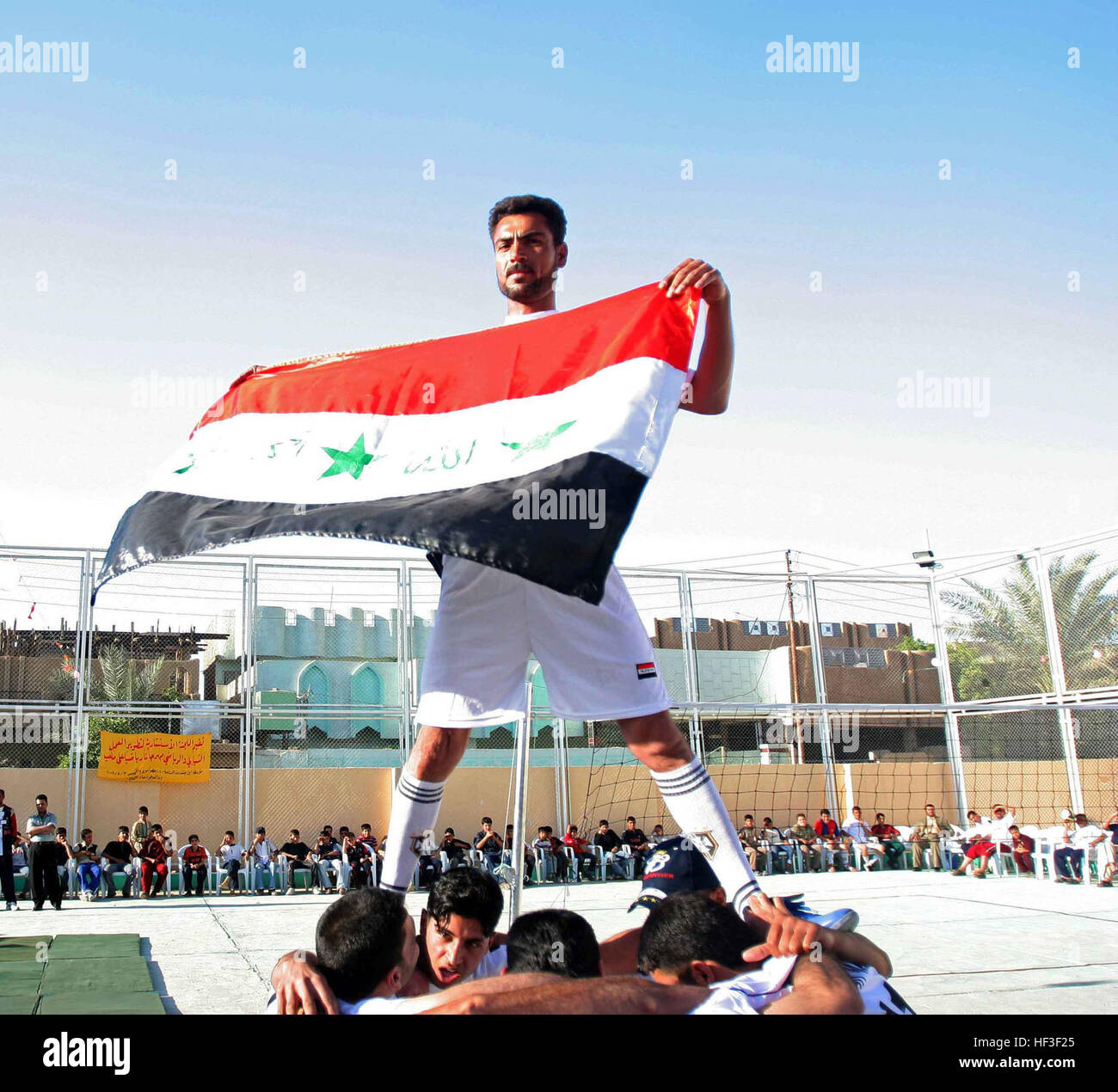 A Fallujah intra-mural volleyball player stands on his teammates ...