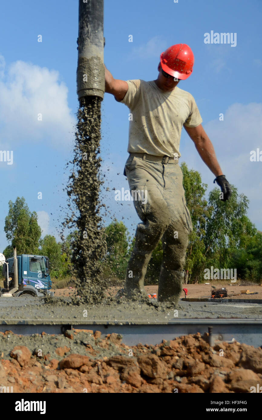 Air Force personnel pour concrete for building foundations during a ...