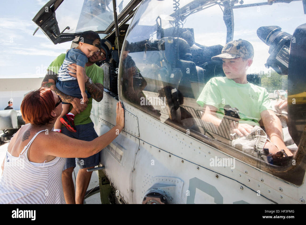 Service members and their families tour a AH-1W Super Cobra assigned to ...