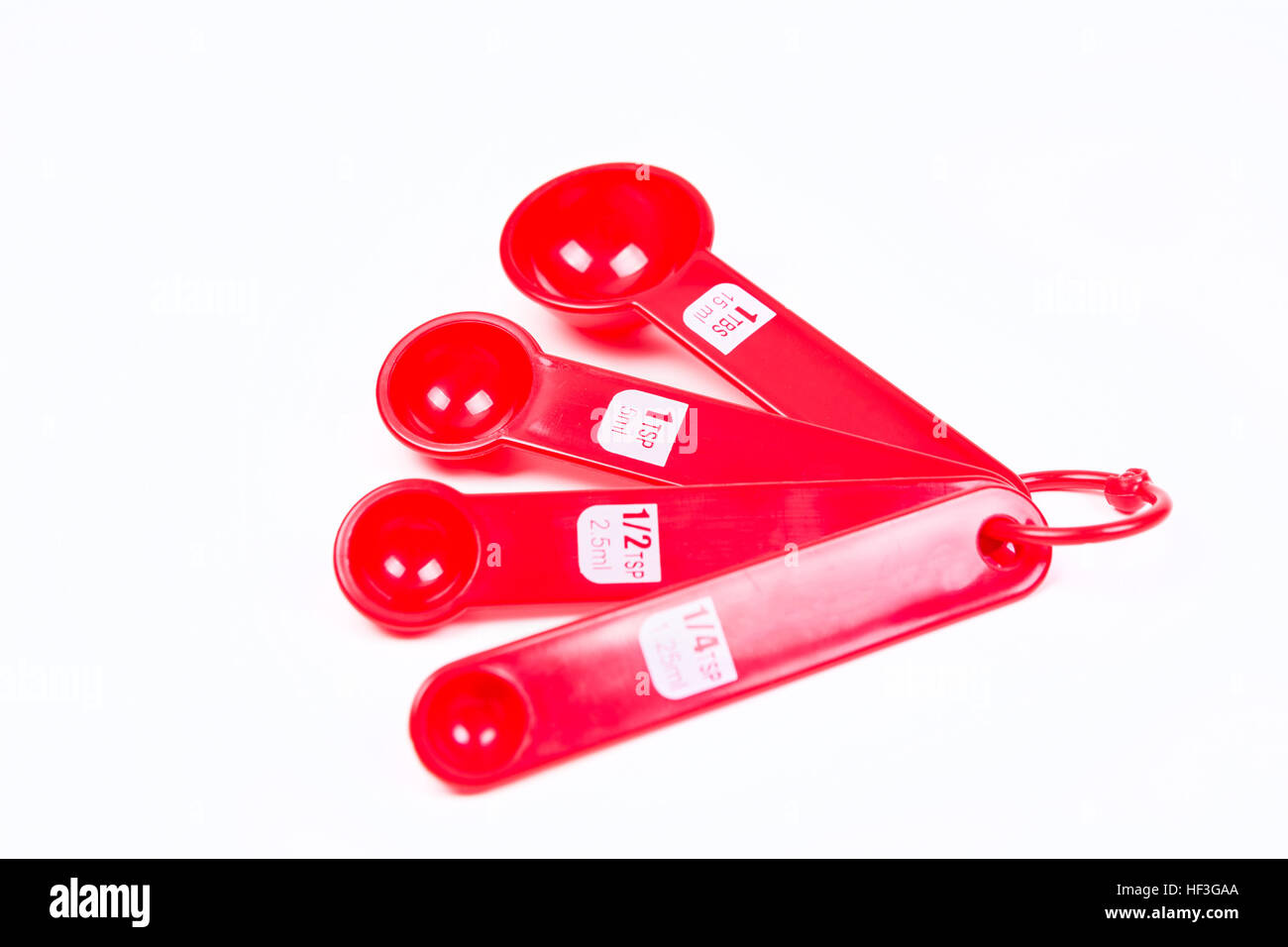 Red measuring spoons isolated on white background Stock Photo - Alamy