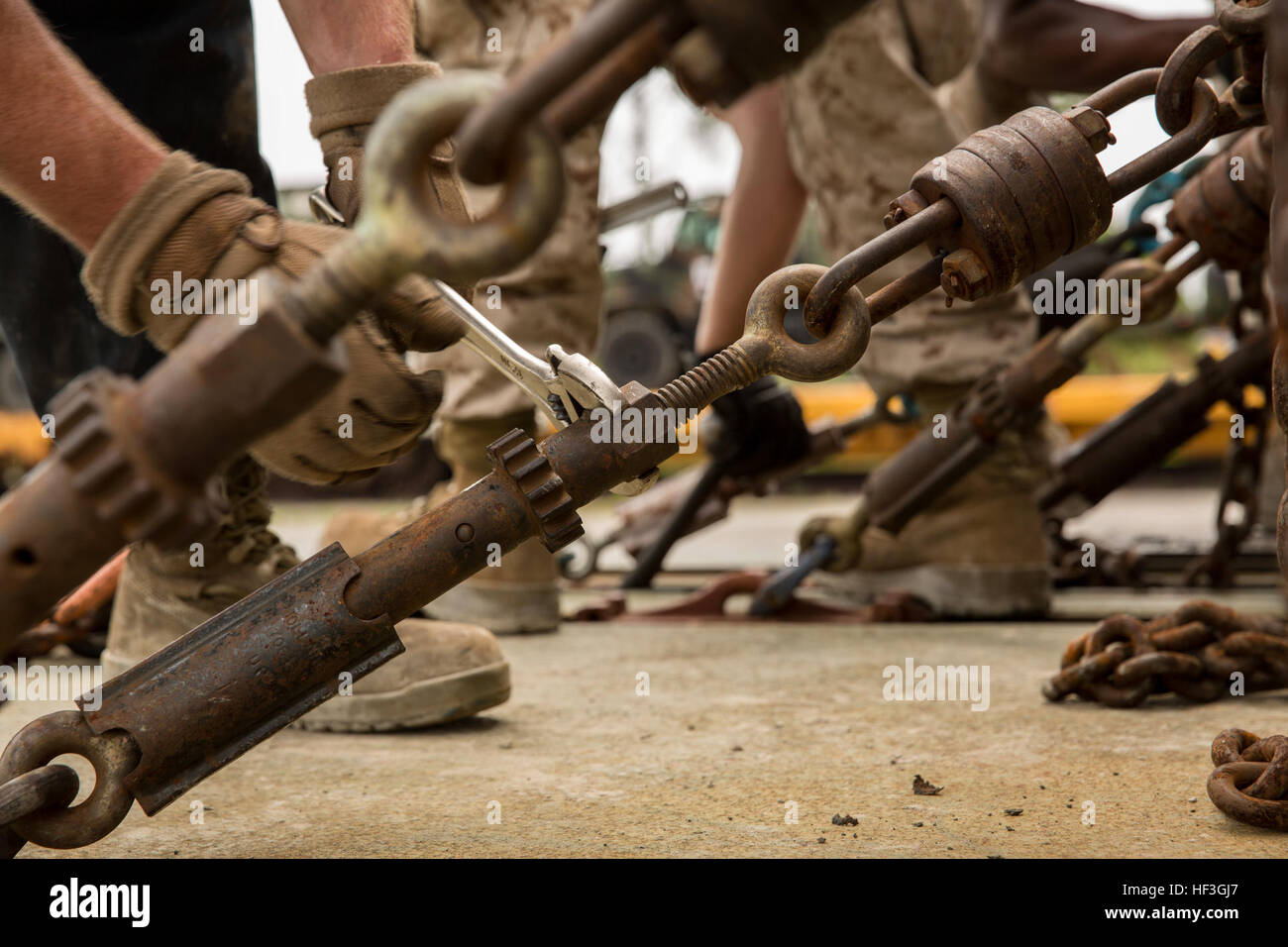 A Marine with Combined Arms Company tightens down a chain attached to ...