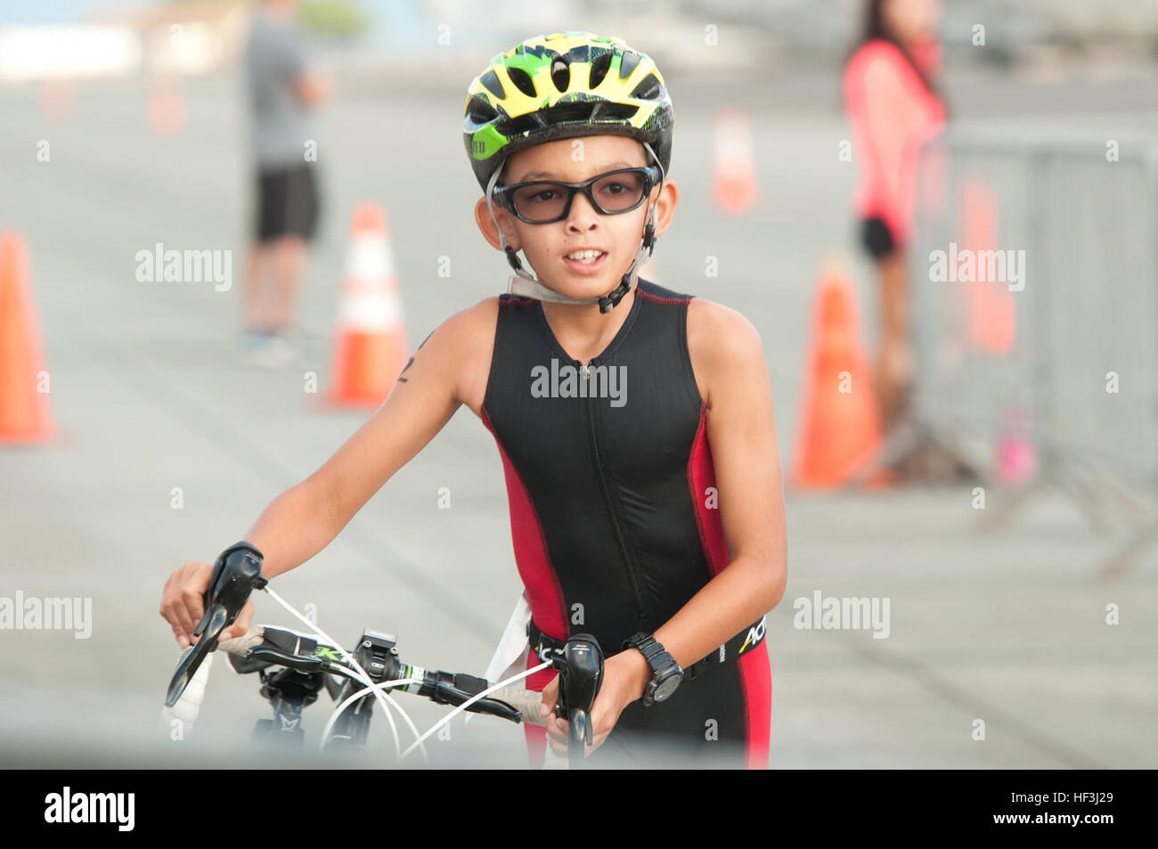 Triathlon participant Matthew Conner walks his bike down the flightline ...