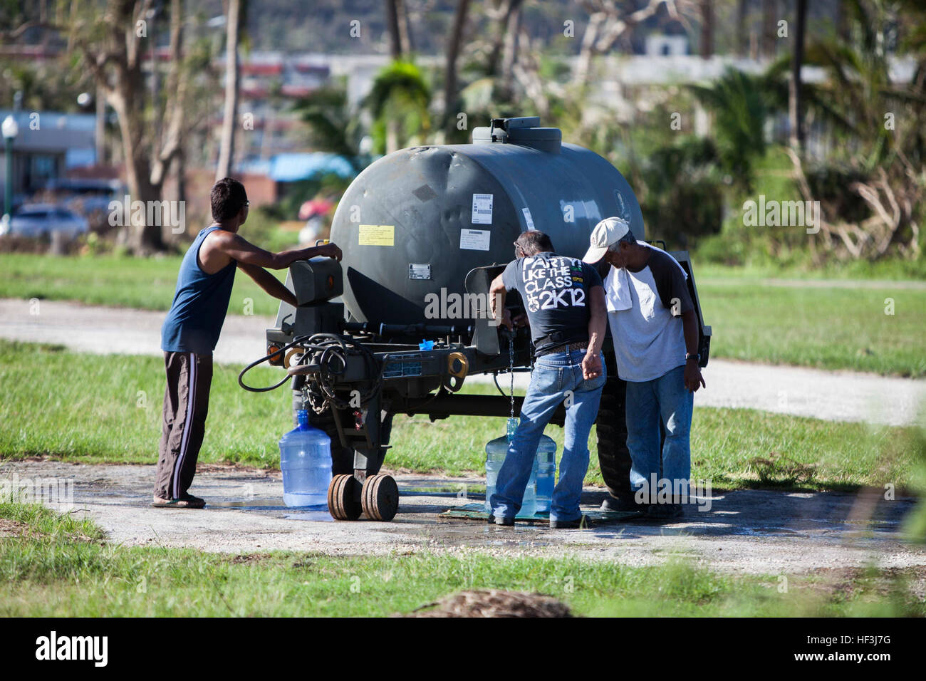 Local civilians fill water jugs from a U.S. Marine water bull at a ...