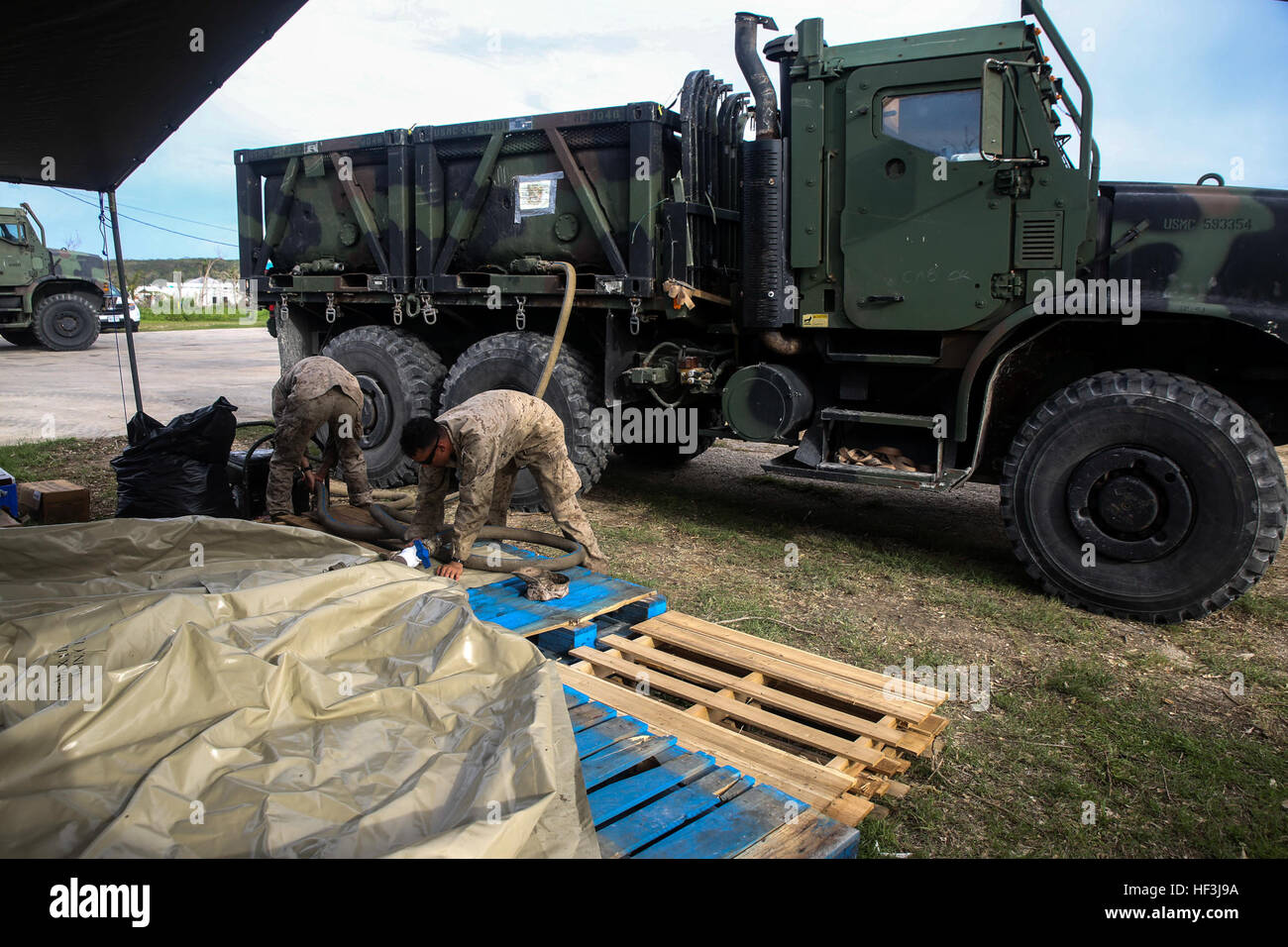 U.S. Marines refill a water bladder at a water distribution site as a ...