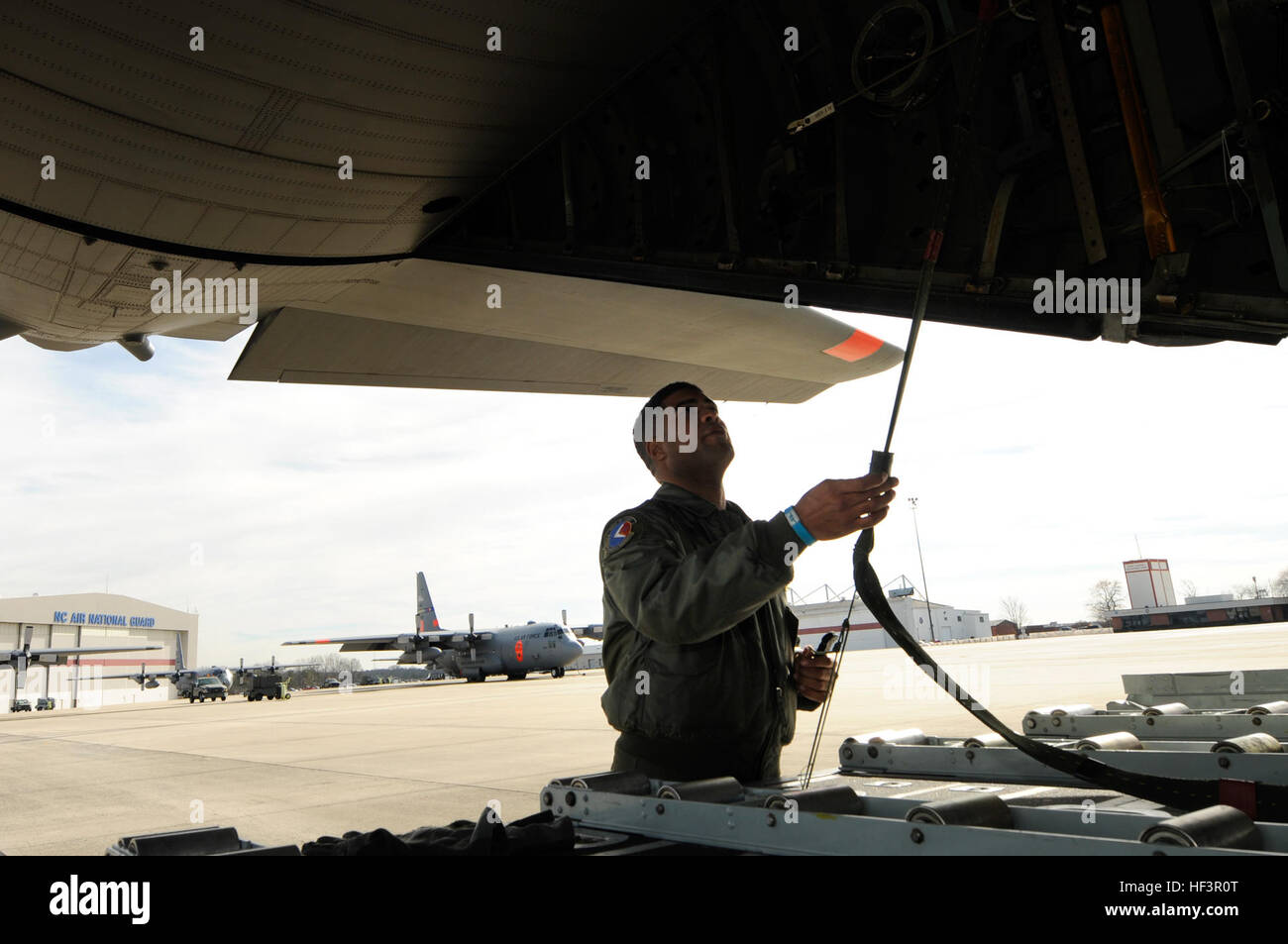 A 156th Airlift Squadron loadmaster secures an extractor parachute on ...