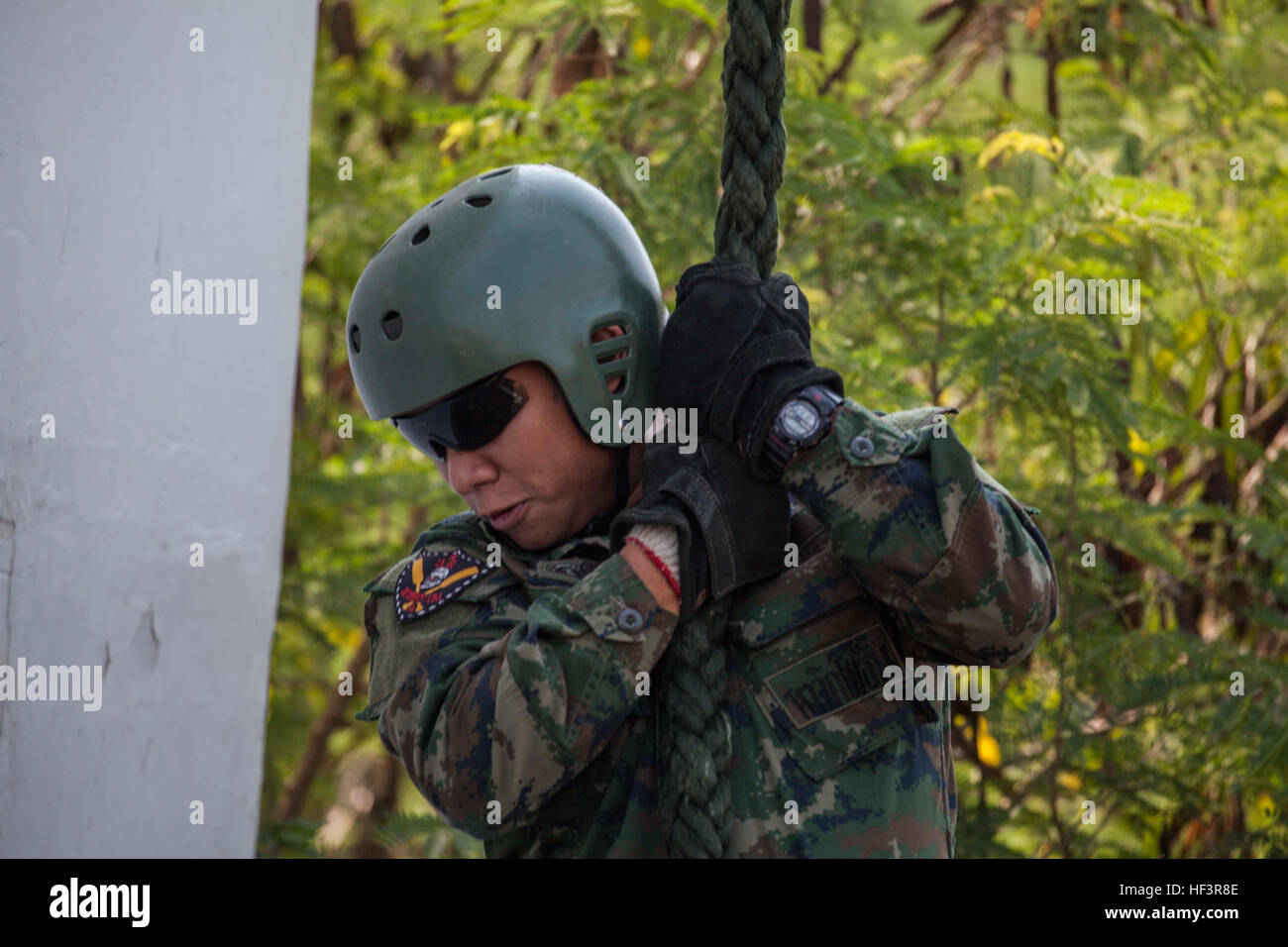 A Royal Thai Marine slides down a rope as he practices fast rope ...