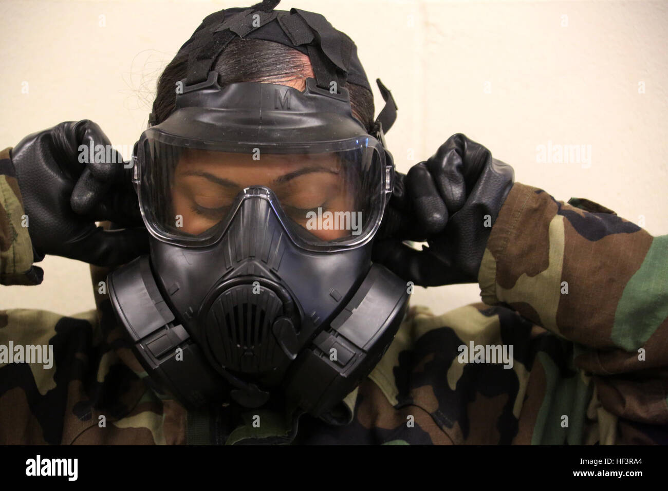 A Marine breaks the seal in her M50 Joint Service General Purpose Mask ...