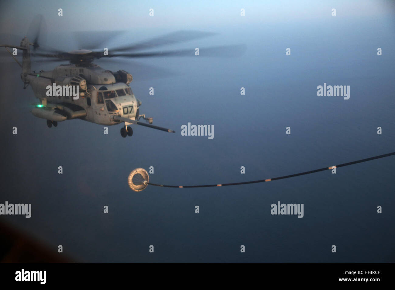 A CH-53E Super Stallion approaches a refueling hose during an aerial ...