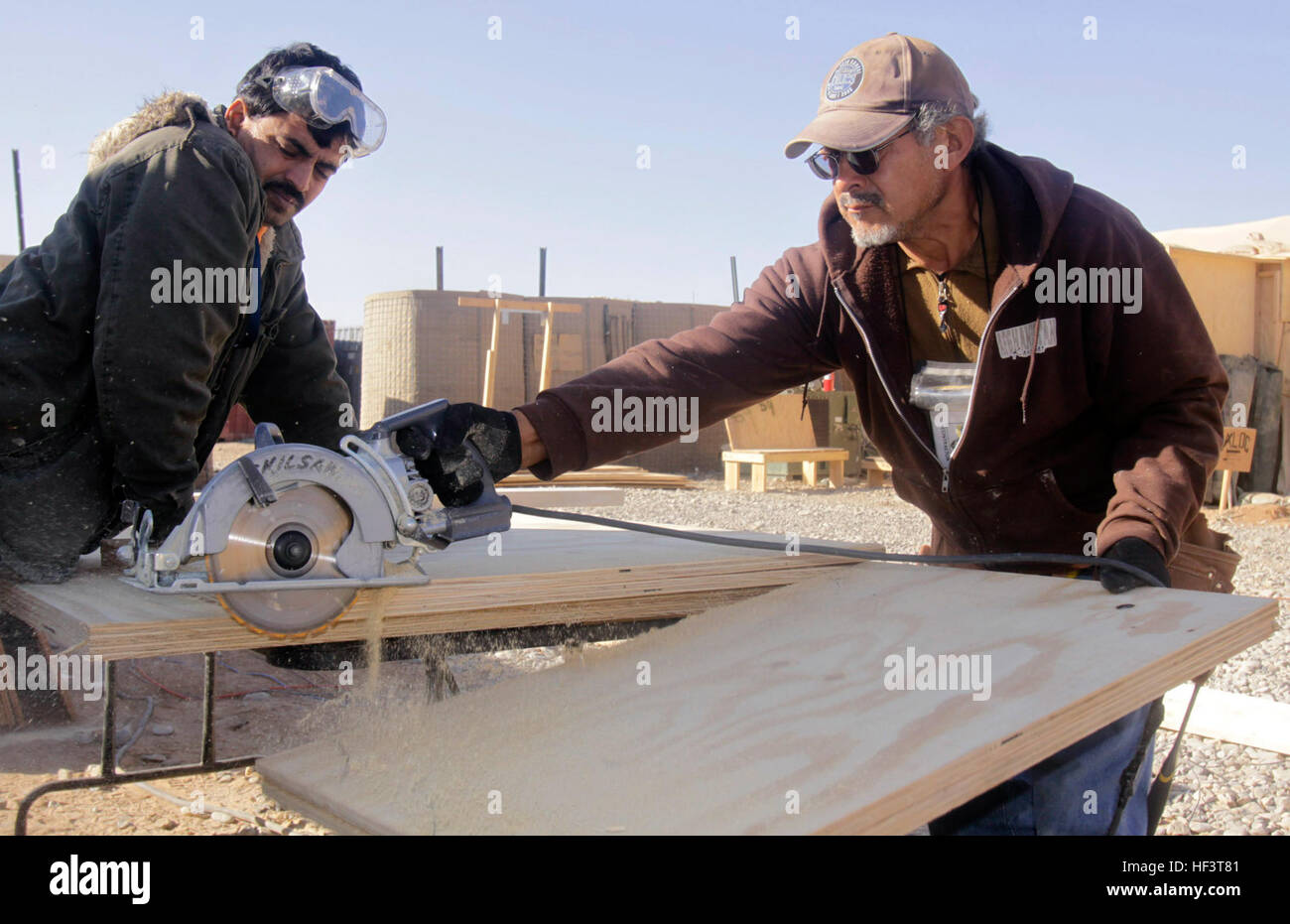 Contractors at FOB Geronimo construct raised wooden floors and assemble ...