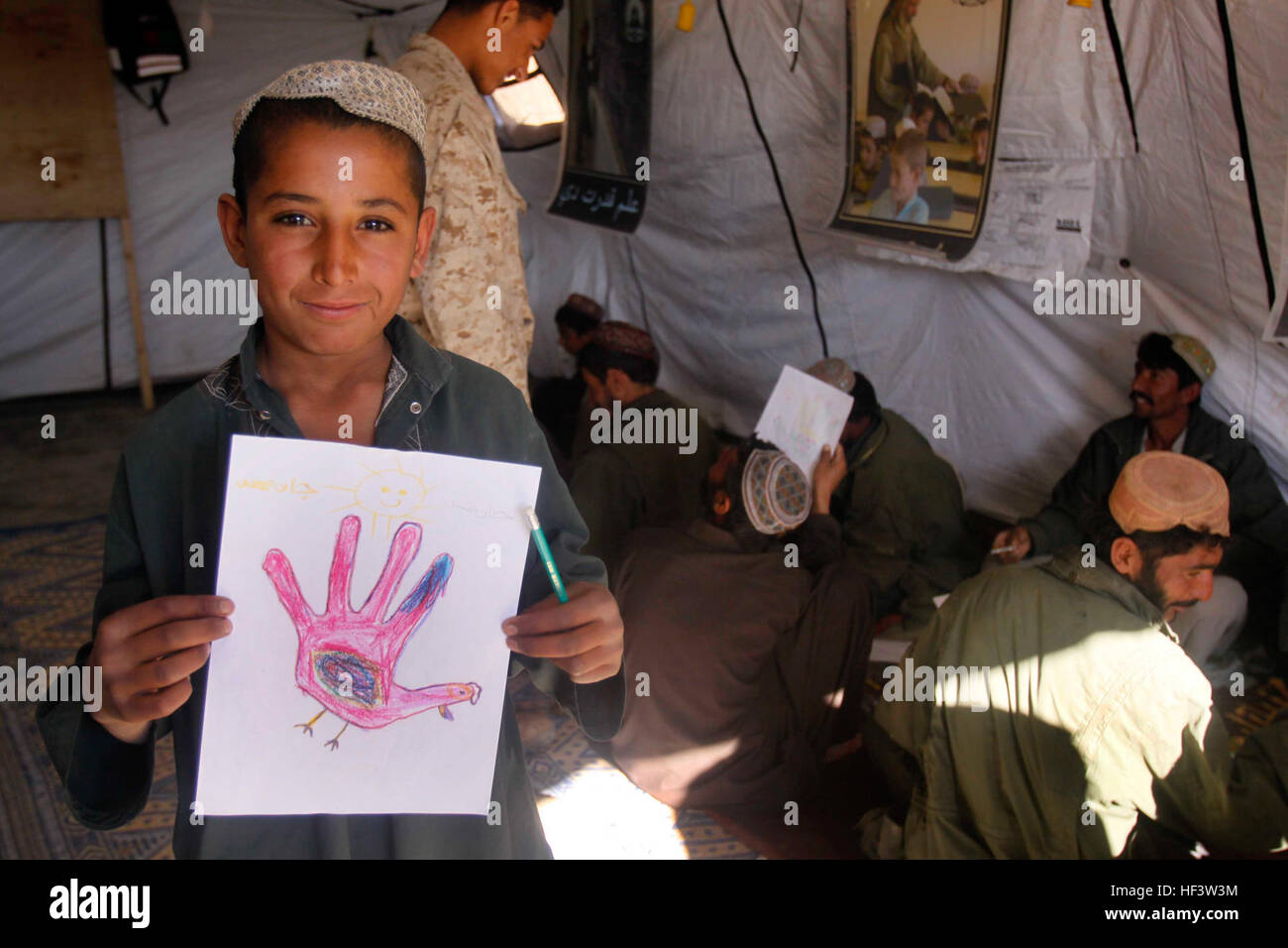 A 10-year-old Afghan boy proudly displays his turkey drawing during the ...