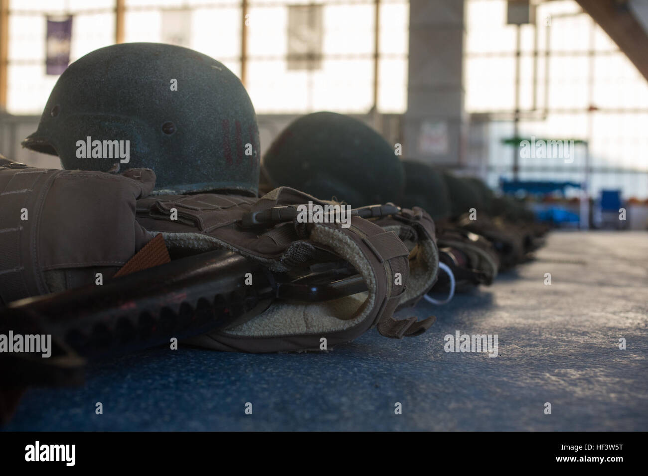 Flak jackets, Kevlar helmets, and training rifles sit on the edge of a ...