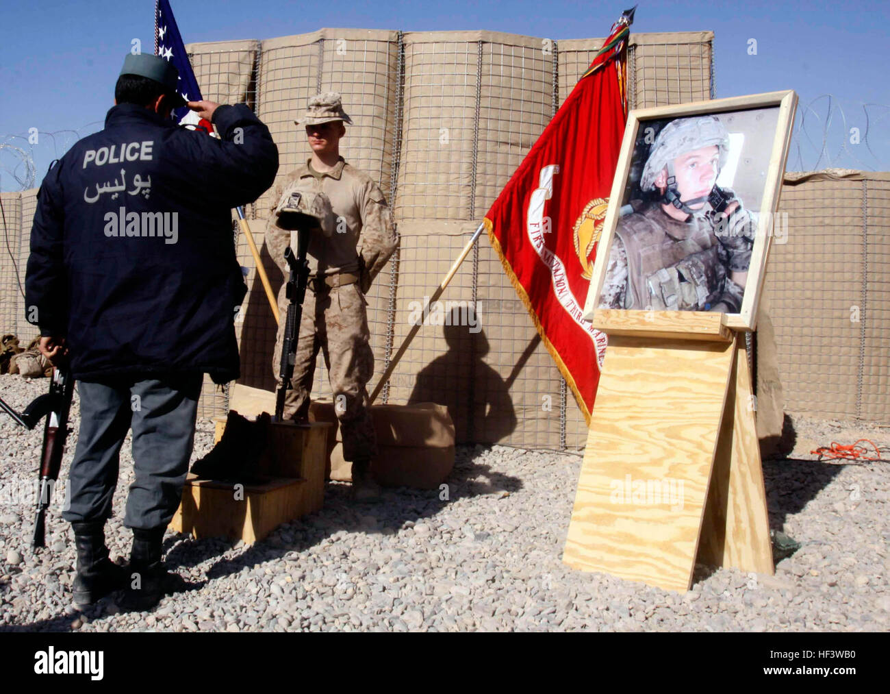 Yousef, a Nawa district police officer, renders a salute in front of ...