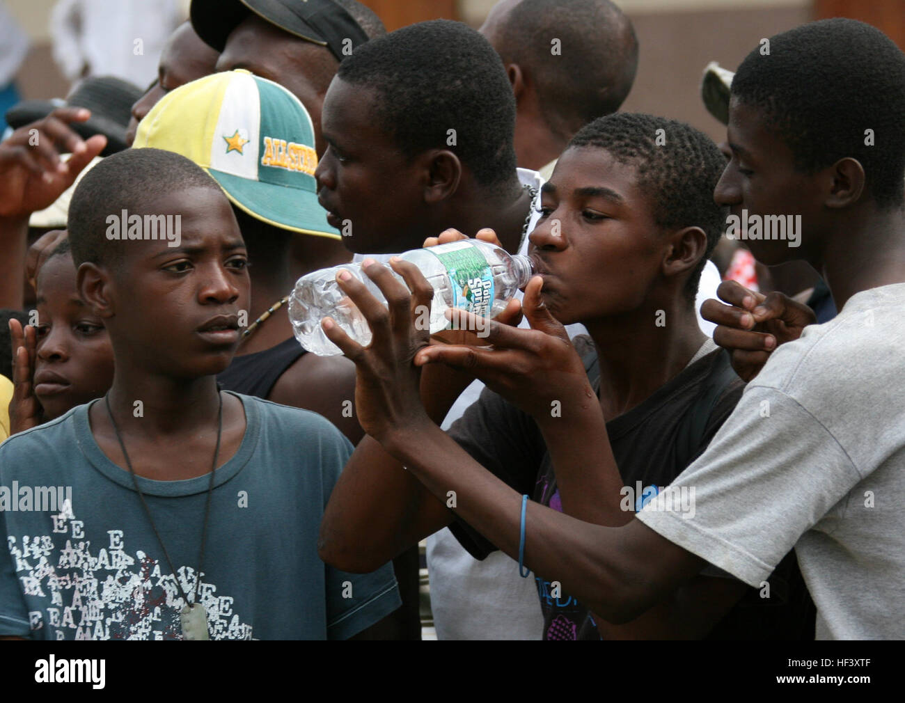 Haitian boys share a bottle of water handed out by Marines and sailors ...