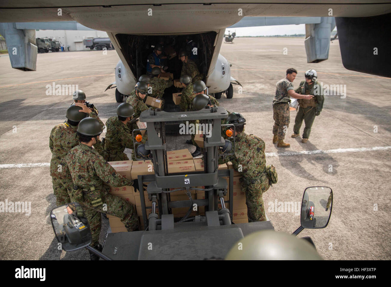 Members of the Japan Ground Self Defense Force load relief supplies ...