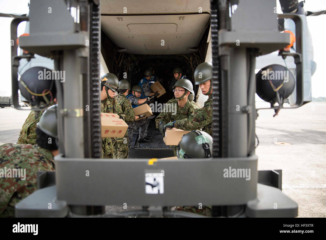 Members of the Japan Ground Self Defense Force load relief supplies ...