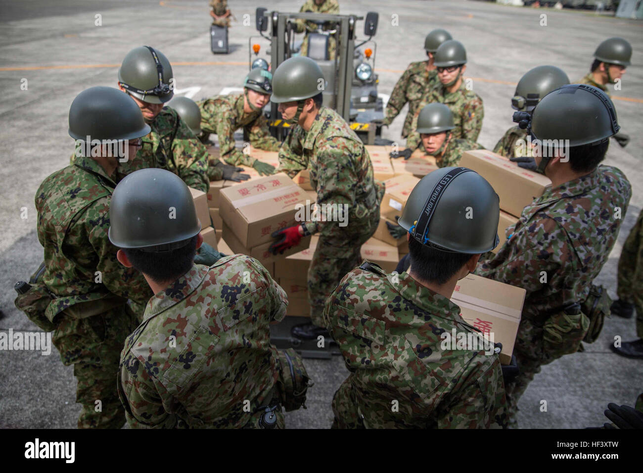 Members of the Japan Ground Self Defense Force load relief supplies ...