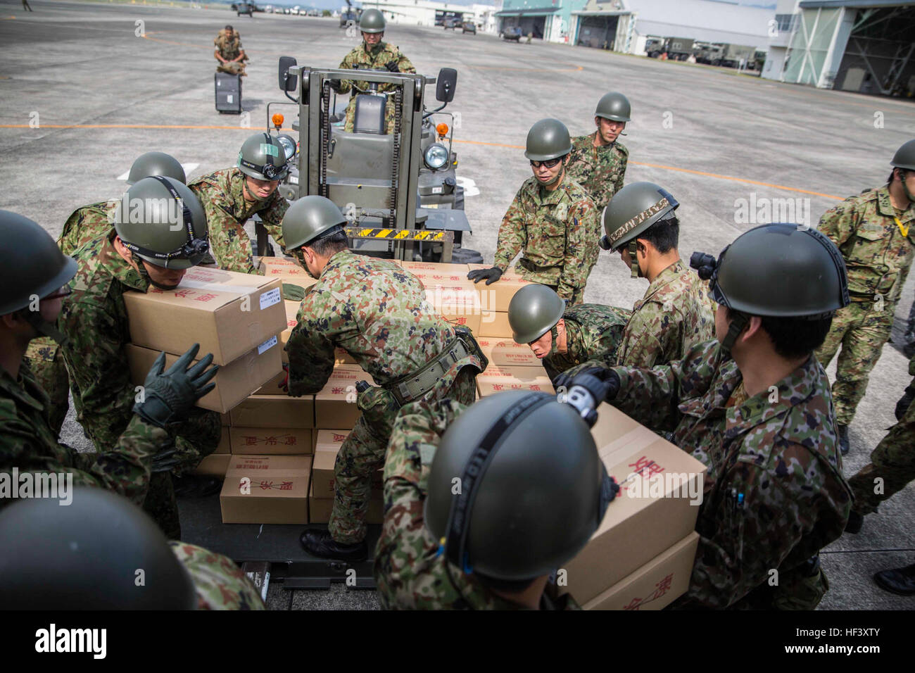 Members of the Japan Ground Self Defense Force load relief supplies ...