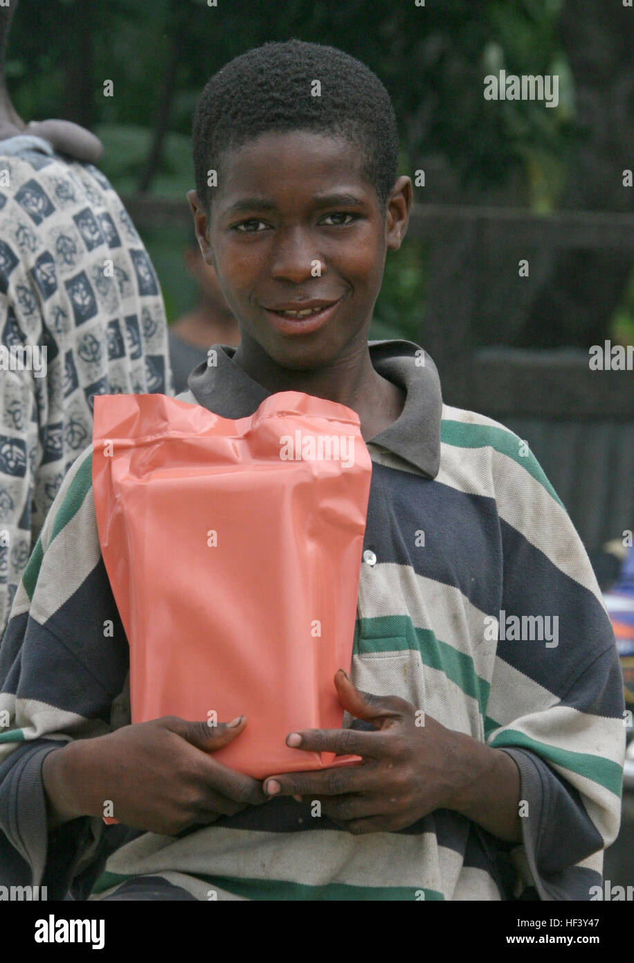 A Haitian boy holds a humanitarian rations pack at a distribution site ...