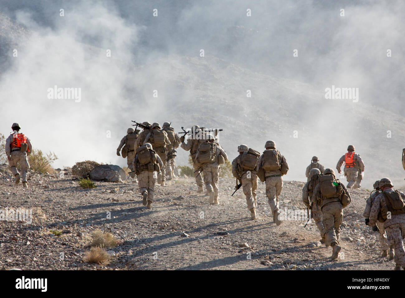 U.S. Marines, orange vests, with Tactical Training Exercise Control Group, run alongside Marines ...
