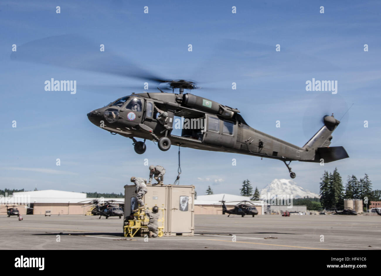 U.S. Soldiers perform a sling load operation with a storage container ...