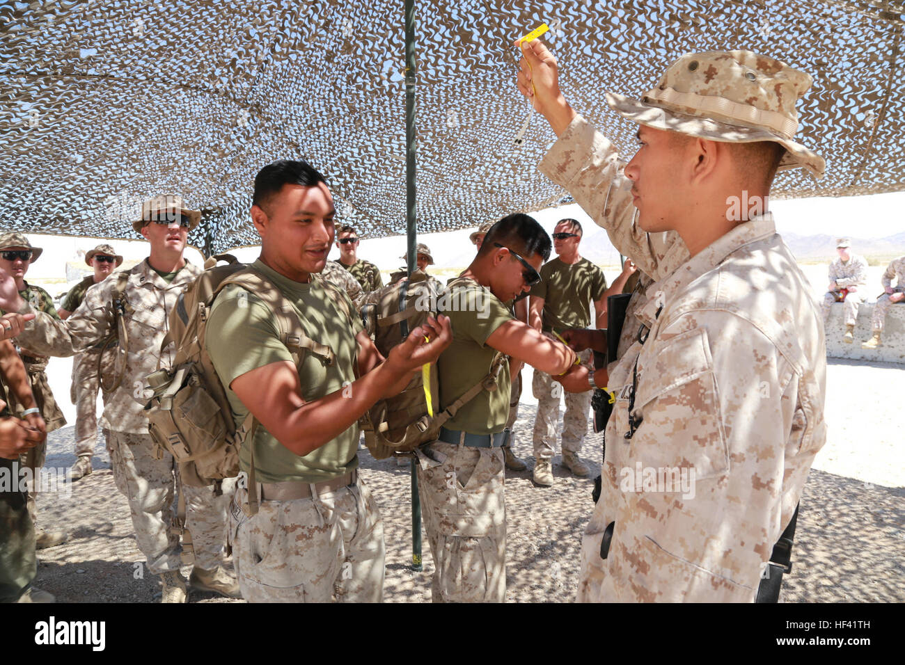 A Marine holds up an identification wristband for role players in an ...