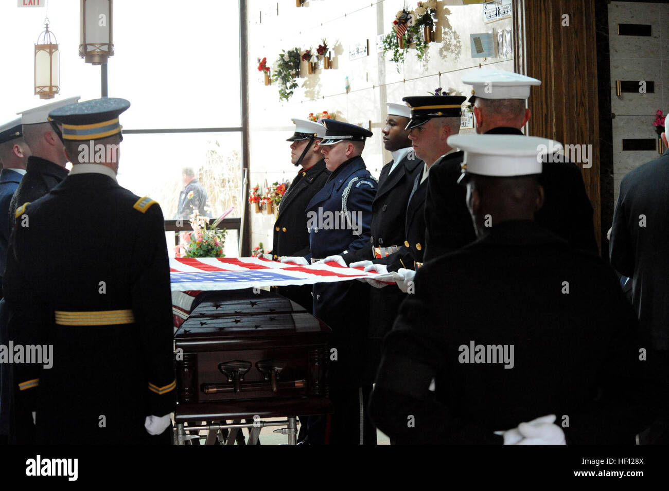 A Joint Service Honor Guard lifted the American flag from the casket ...
