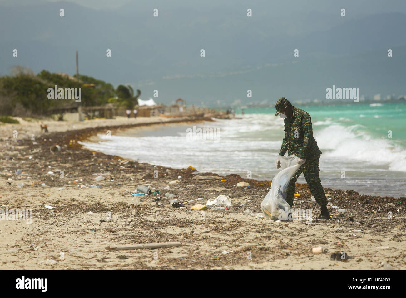 A Barbados Defence Force soldier scans the sand for trash during a ...