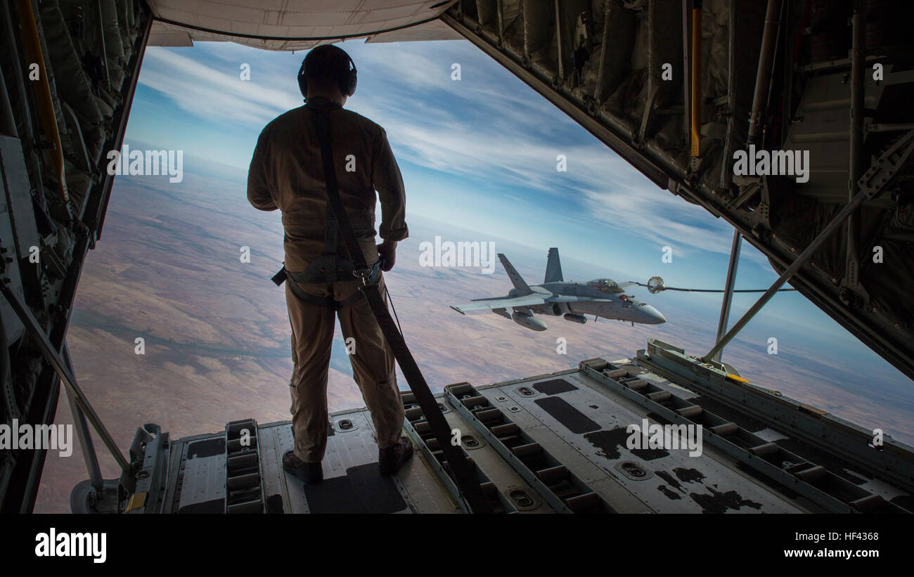 A Marine crewmaster with VMGR-152 monitors an F/A-18C Hornet from VMFA ...