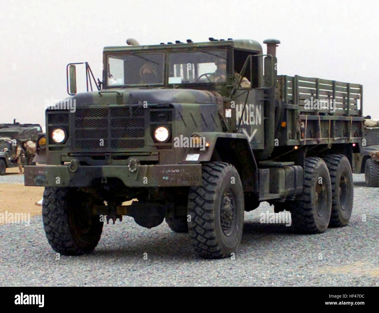A US Marine Corps (USMC) M923 (6X6) 5-ton cargo truck heads a convoy ...