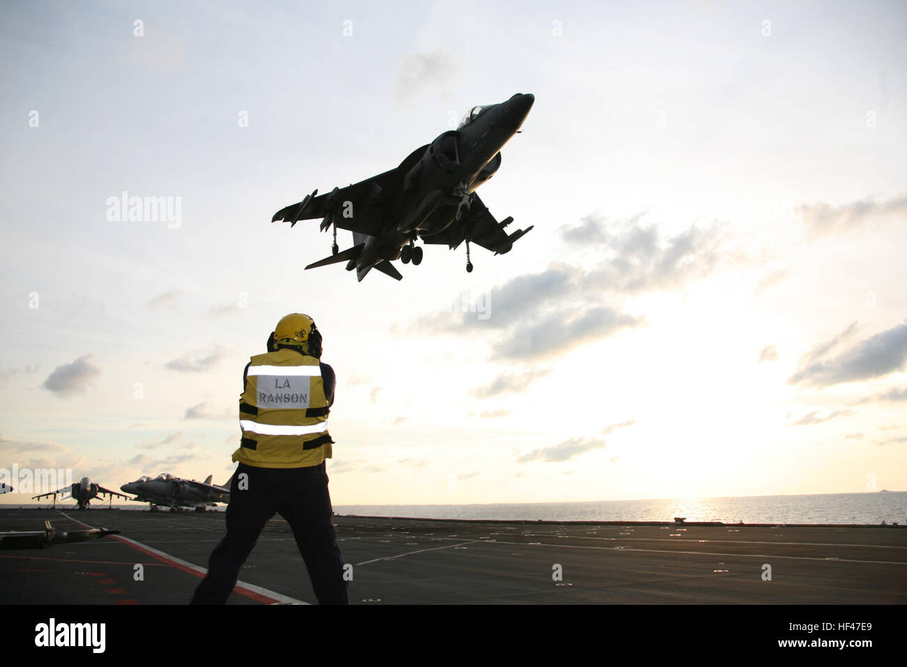 A Royal Navy sailor directs Lt. Col. Terrence J. Dunne, an AV-8B ...