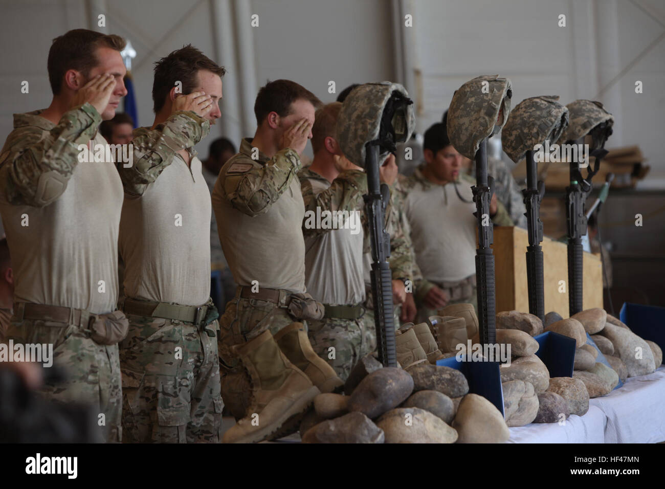 U.S. Airmen salute during a memorial ceremony for fallen Service ...