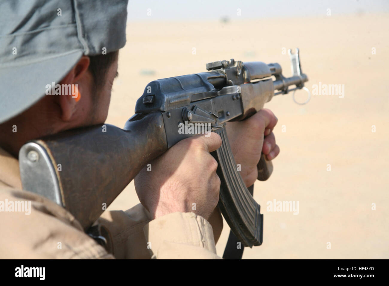 An Afghan National Police recruit fires an AK-47 rifle during weapons ...