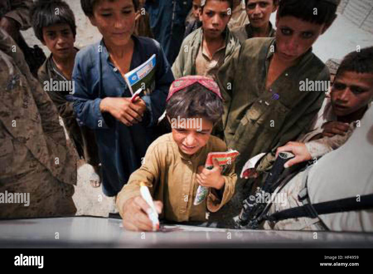 Muhammad Wali, 8, writes letters of the alphabet on a whiteboard during ...