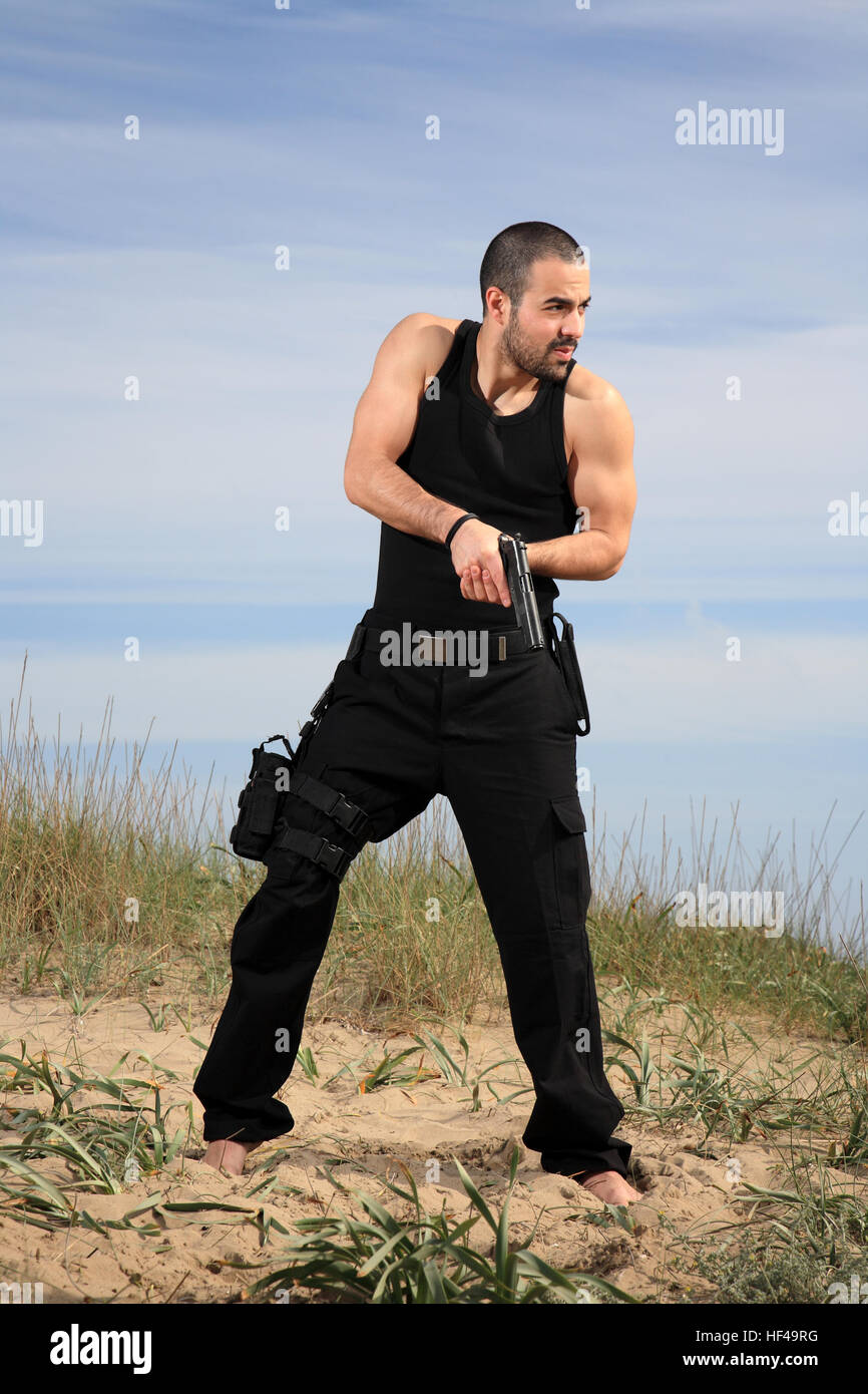 young man bodyguard with a gun outdoor Stock Photo - Alamy