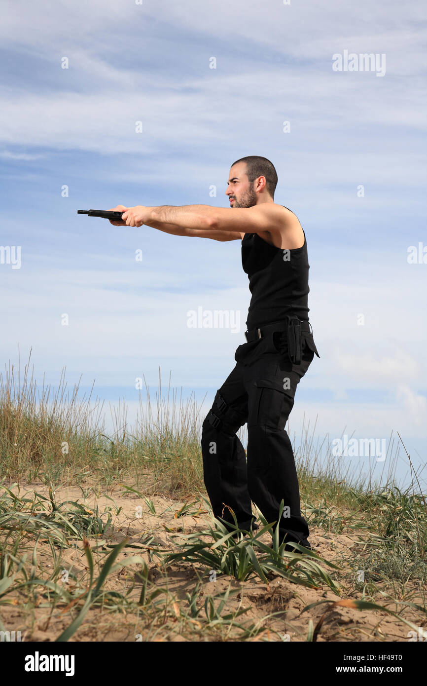 young man bodyguard with a gun outdoor Stock Photo - Alamy