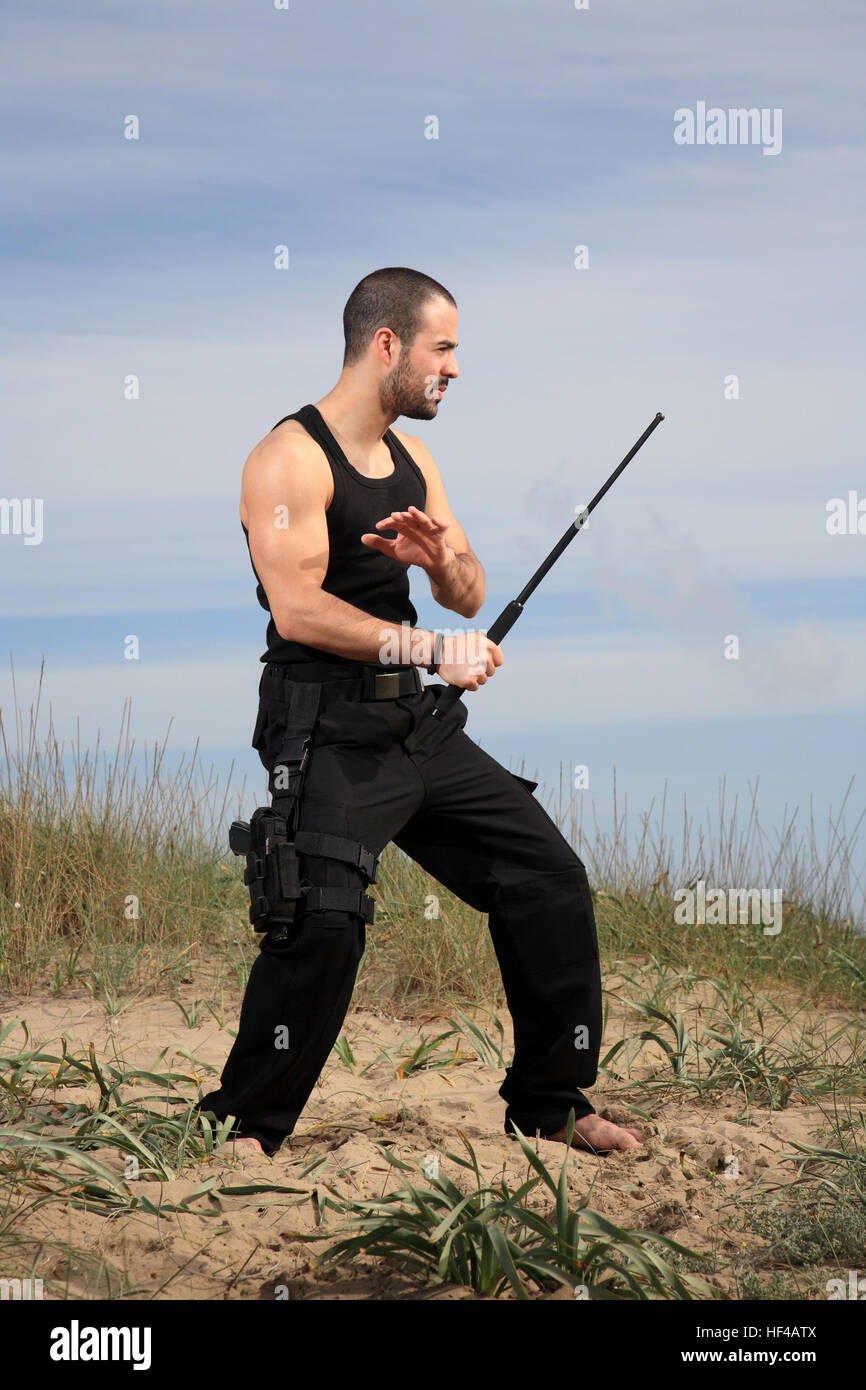 bodyguard with black uniform and a crowbar Stock Photo - Alamy