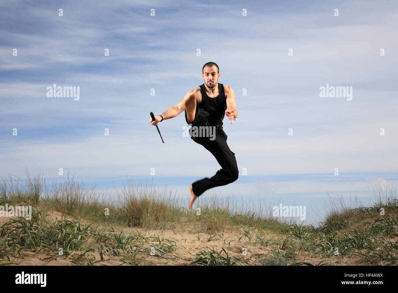 bodyguard with black uniform and a crowbar jumping Stock Photo - Alamy