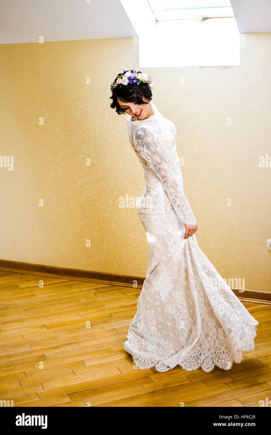 Beautiful bride in white lace dress and flowers in hair. Waiting in ...